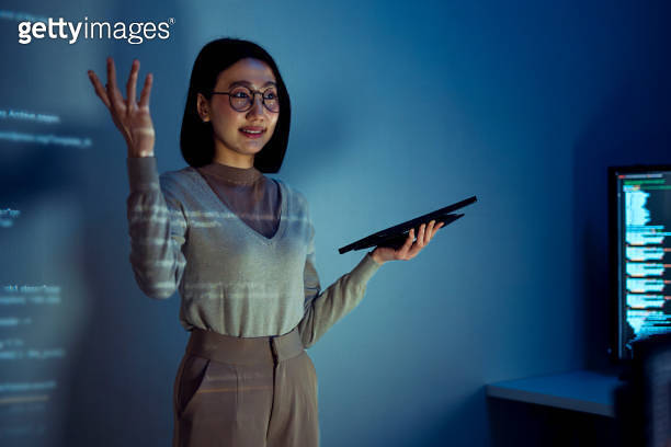 asian woman programmer standing in front of a screen with code ...