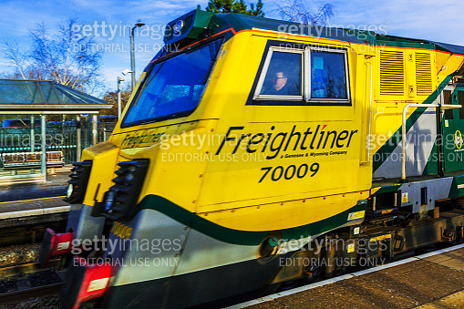 A freightliner locomotive is pulling a goods / freight train with ...