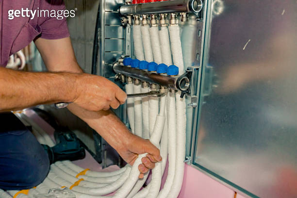 Technician is adjust distribution and control panel of heat pump ...