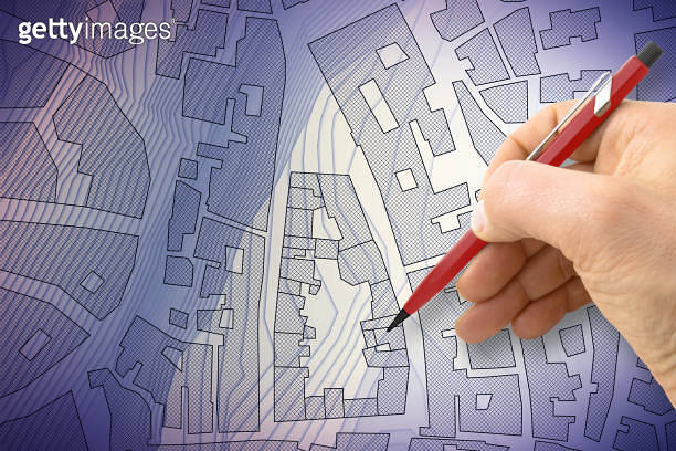 Engineer drawing an imaginary city map of territory with buildings ...