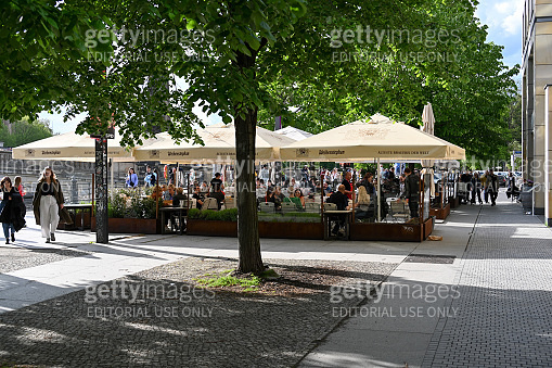 Locals and tourists enjoy the beautiful weather on the terrace of the ...