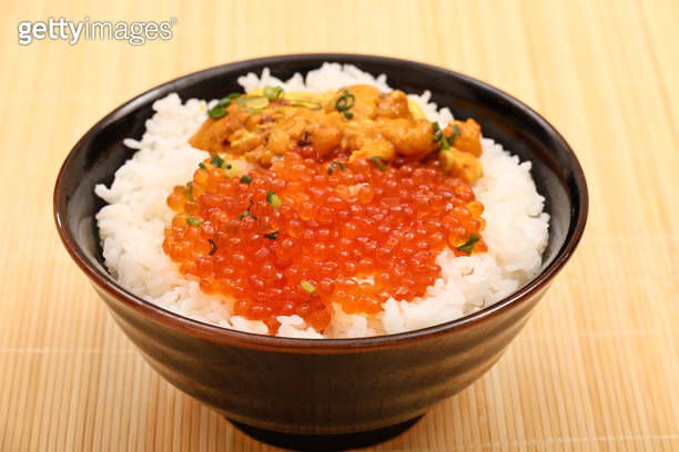 A bowl of rice topped with sea urchin and salmon roe, seafood ...