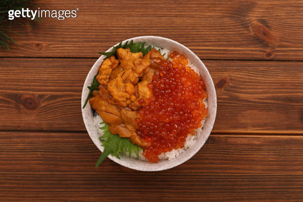 A bowl of rice topped with sea urchin and salmon roe, seafood ...