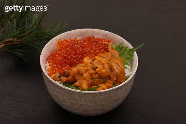 A bowl of rice topped with sea urchin and salmon roe, seafood ...