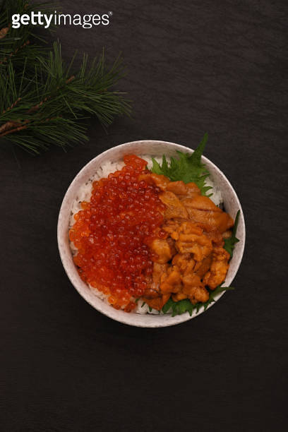 A bowl of rice topped with sea urchin and salmon roe, seafood ...