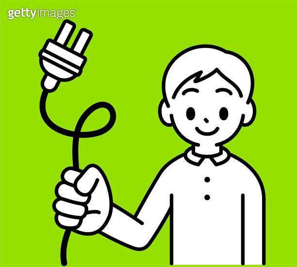 A boy holding an electric plug, smiling and looking at the viewer ...