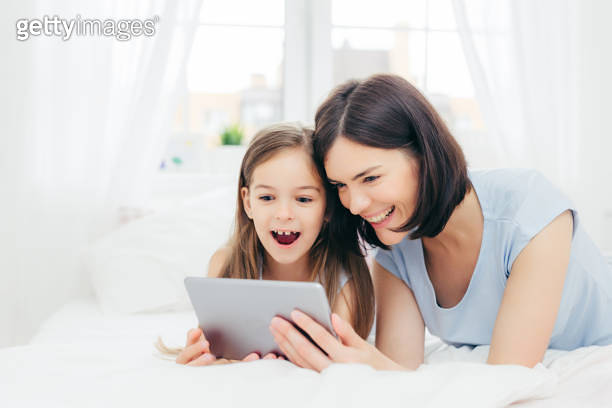 A mother and daughter explore the digital world together, marveling at ...