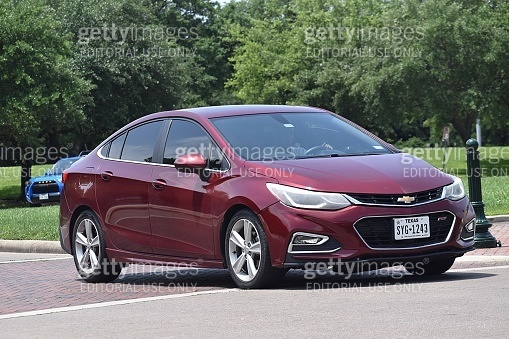 A maroon Chevy Cruze economy sedan driving near a nature reserve. 이미지 ...
