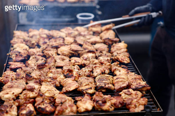 Man grilling chicken on an open flame 이미지 (2157160504) - 게티이미지뱅크