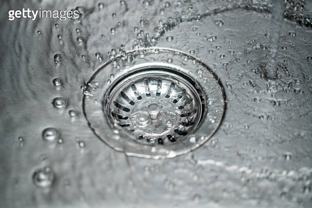 Kitchen sink drain close-up with pouring water 이미지 (1921700577) - 게티이미지뱅크