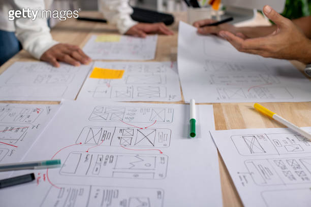 Ux Ui Designers Discussing And Brainstorming On Wireframes For A Website And Mobile App