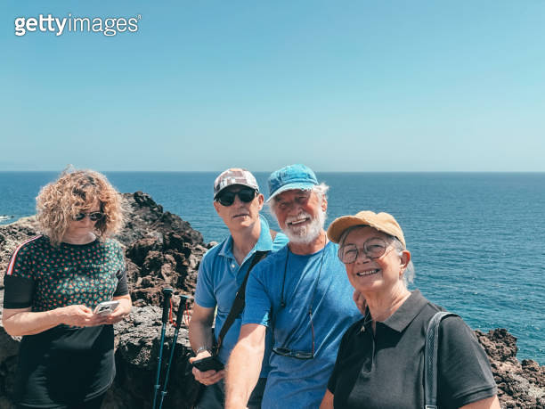 Group of people in outdoor excursion at sea, four men and women looking ...