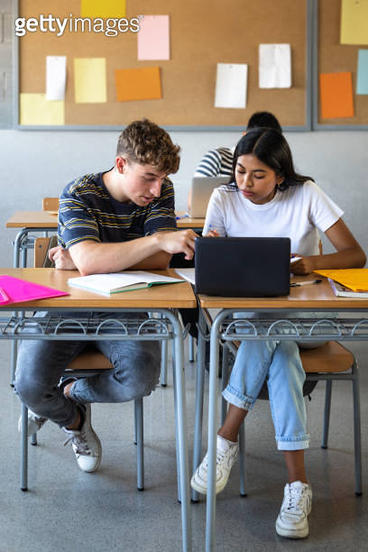 Teen boy and native american female high school students in class ...