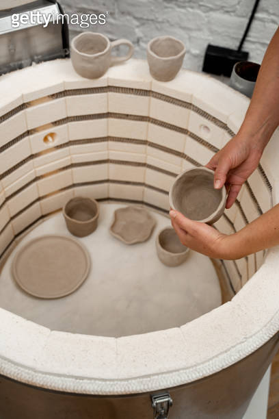 The process of firing clay products. Placing pottery in a muffle ...