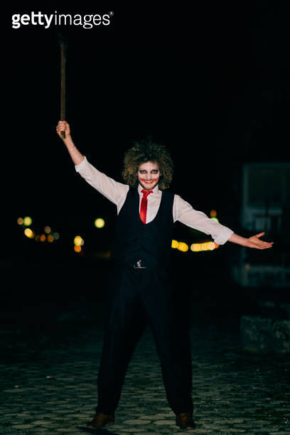 A mysterious figure, disguised as an assassin in a suit with wild hair ...