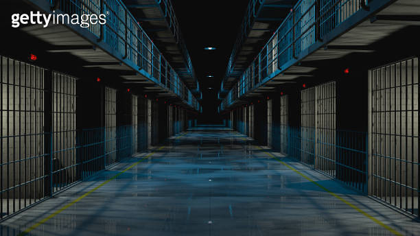 Inside prison corridor at night. cells with lights on and wet floor ...