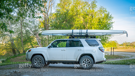 Toyota 4Runner SUV with an expedition canoe on roof racks at a shore of ...