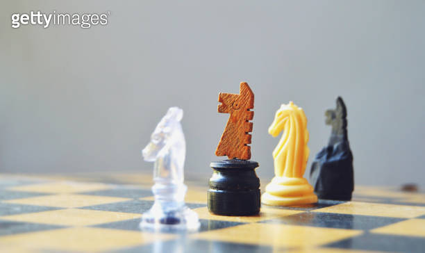 Horizontal photograph of four different knight chess pieces variety or ...
