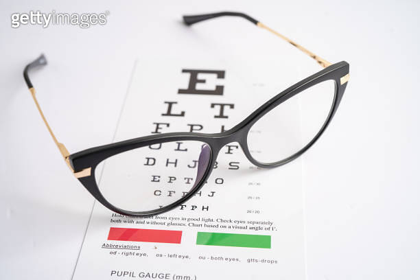 Glasses on eye testing exam chart to check eyesight accuracy of reading ...