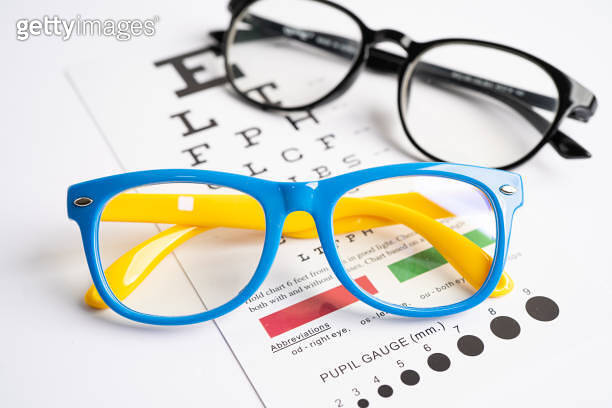 Glasses on eye testing exam chart to check eyesight accuracy of reading ...