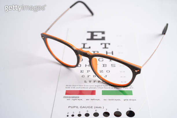 Glasses on eye testing exam chart to check eyesight accuracy of reading ...