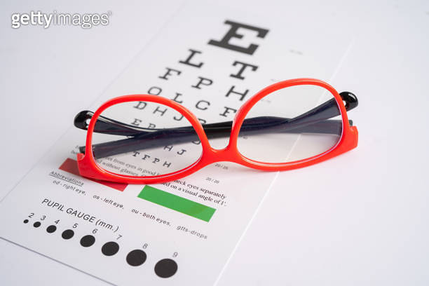 Glasses on eye testing exam chart to check eyesight accuracy of reading ...
