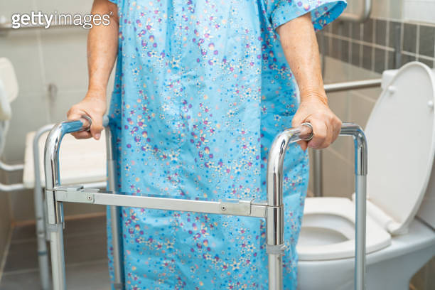 Asian elderly woman patient use walker and toilet bathroom handle ...