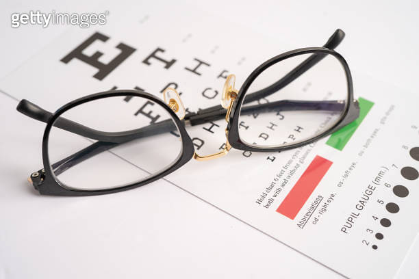 Glasses on eye testing exam chart to check eyesight accuracy of reading ...