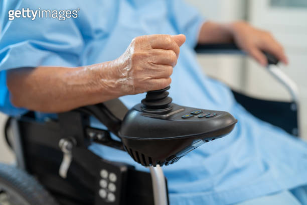 Asian senior woman patient on electric wheelchair with remote control ...