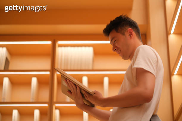 smile young man hold and read book in library. low angle 이미지 ...