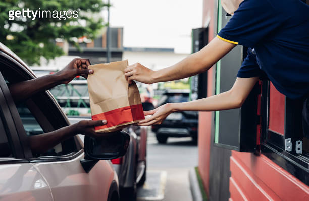 Hand Man in car receiving coffee in drive thru fast food restaurant ...