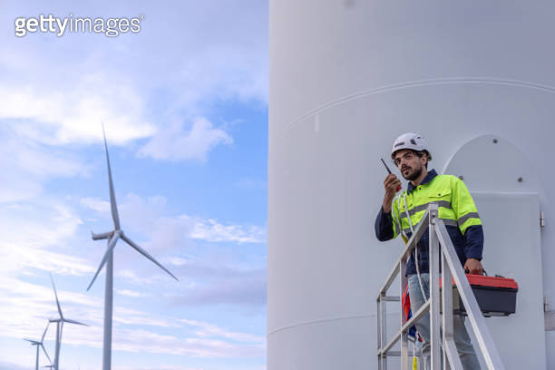 Professional Man Maintenance engineers working in wind turbine farm at ...