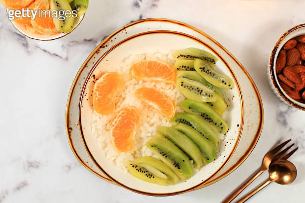 Rice pudding with kiwi, honey, tangerines and almonds. Healthy ...