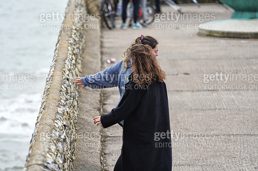 a Person fishing near"Afloat" Groyne Brighton: bronze circular donut ...