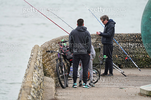 a Person fishing near"Afloat" Groyne Brighton: bronze circular donut ...