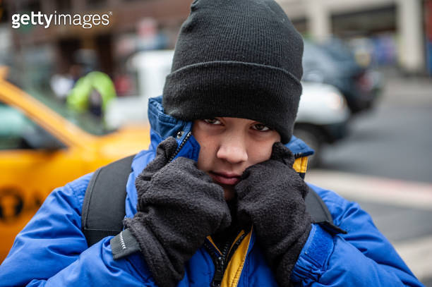 child feeling very cold in a winter windy cold day in New York city ...