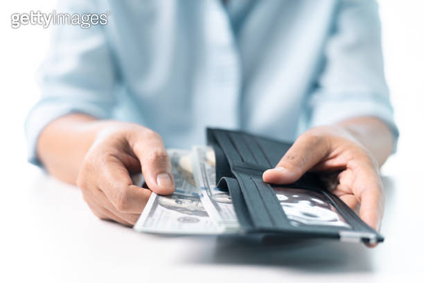 She carefully counted the dollar bills in her hand, managing her ...