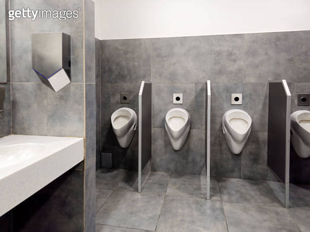 The bathroom interior is lined with white ceramic tiles. Oval ceramic ...