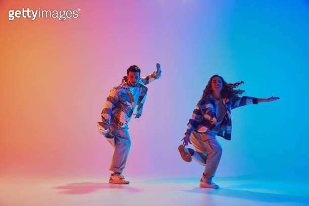 Full length portrait of hip-hop dancers performing in motion against ...