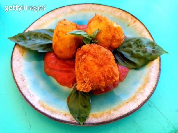 Arrancini (deep fried rice balls) filled with spinach, tomato sauce and ...