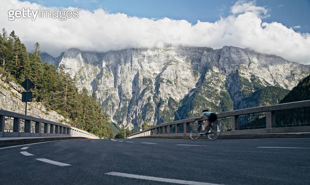 Blurred Motion of Sporty Woman Riding Bike on Road Leading Towards ...