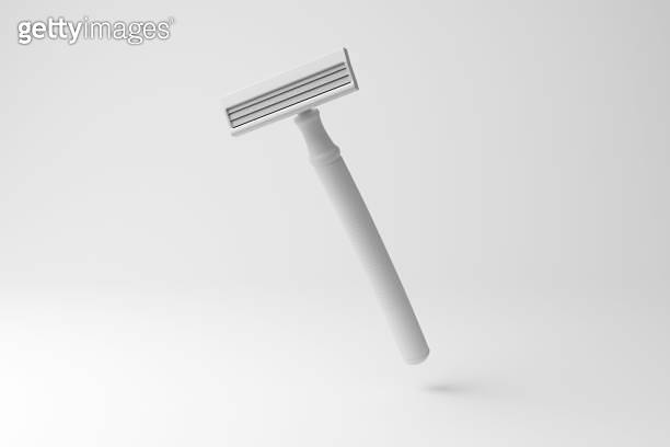 White triple blade disposable razor floating in mid air in monochrome ...