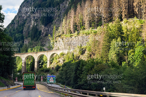 A truck driving through a valley road to transport cargo across country ...