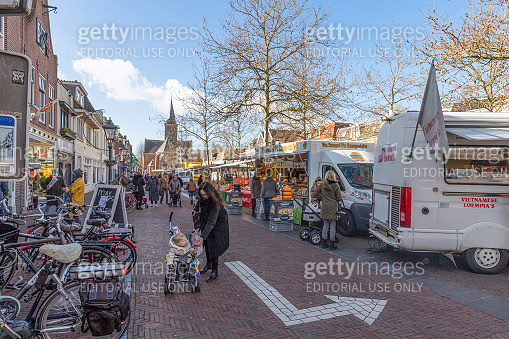 People do their shopping at the market in the center of the village of ...