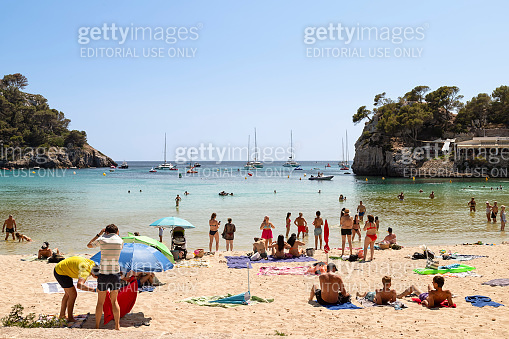 People enjoy the beach at Cala Galdana on the Spanish island of Menorca ...