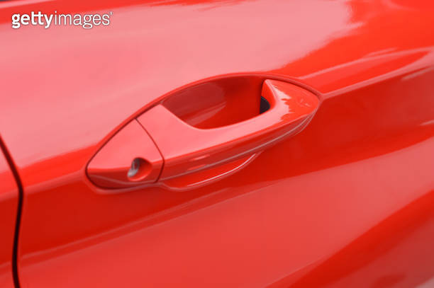 Here's a close-up shot of the sleek, vibrant red car door handle ...