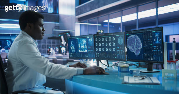 Black Male Neuroscientist Using Desktop Computer To Analyze MRI Scans ...
