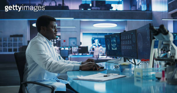 Black Male Neuroscientist Using Desktop Computer To Analyze MRI Scans ...