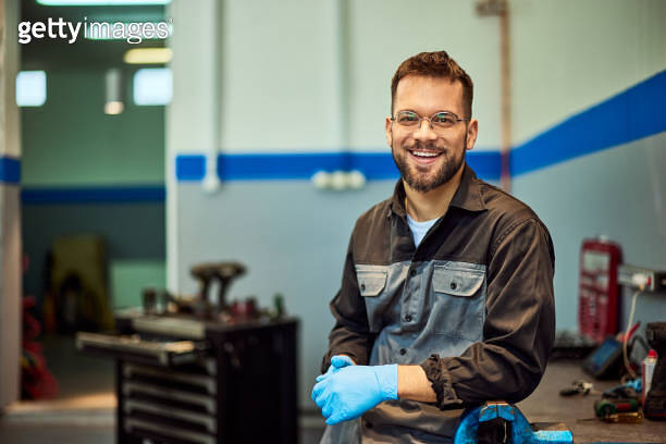 A smiling mechanic man is standing in his garage, posing for the camera. 이미지 (2093794512) - 게티이미지뱅크