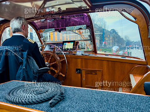 Captain behind boat steering wheel, rear view (1871146833) - 게티이미지뱅크